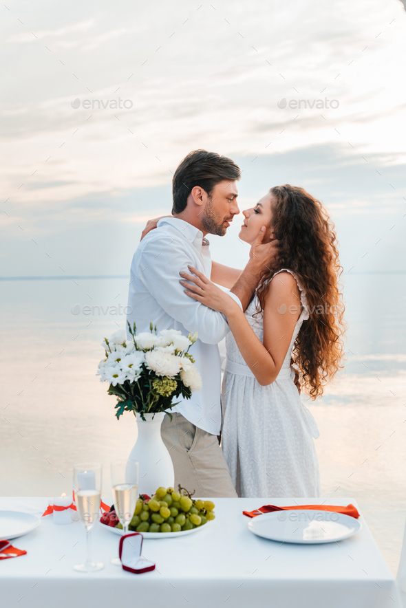happy couple hugging and kissing near table with proposal ring Stock ...
