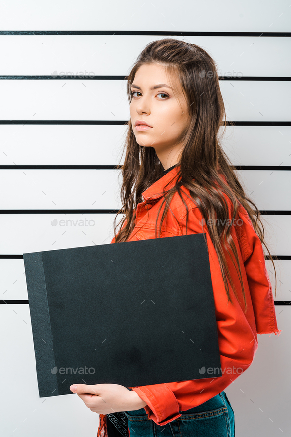 arrested young woman posing with empty prison board in front of police ...