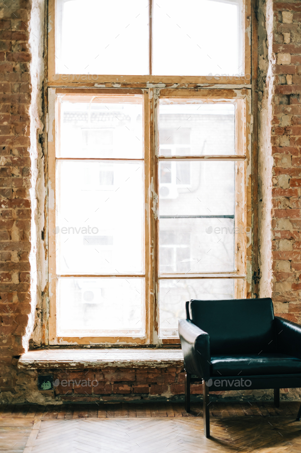 Big wooden window with white sofa in old vintage living room with brick ...
