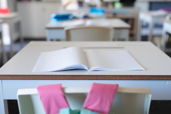 Close-up of open book on desk in classroom Stock Photo by Wavebreakmedia