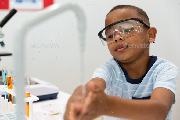 African american elementary boy washing hands during chemistry ...