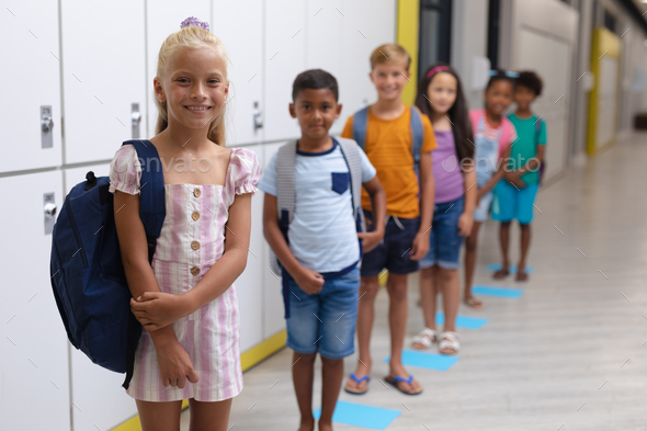Portrait of smiling multiracial elementary school students standing in ...