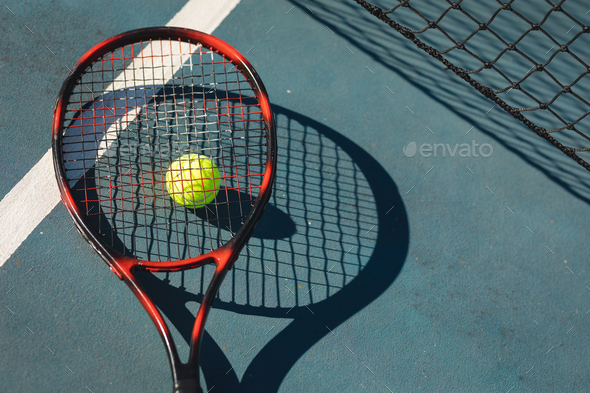 Overhead view of red tennis racket on ball and court with line during ...