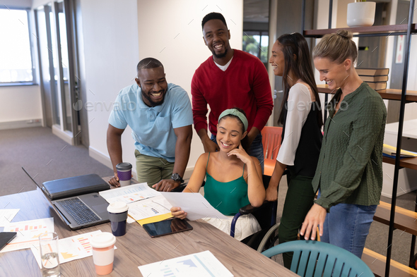 Happy multiracial business colleagues planning strategy during meeting ...