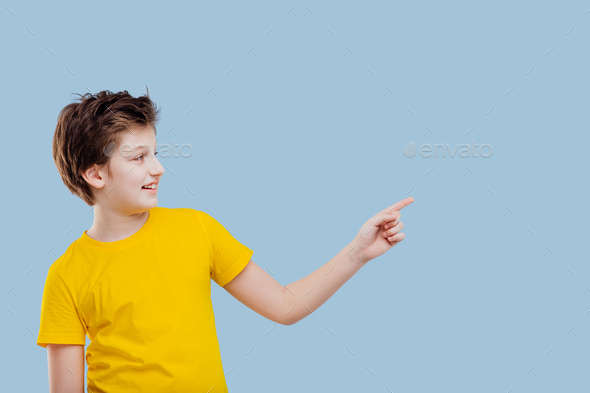 young boy pointing his finger to the left side, Stock Photo by alexlucru123