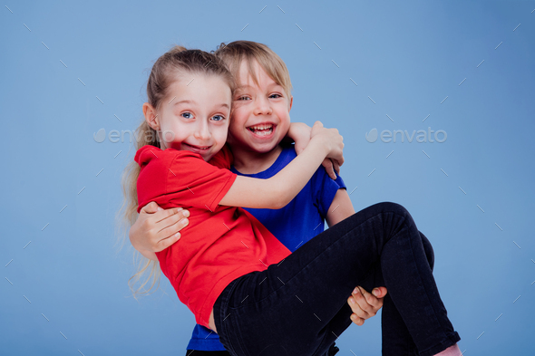 Cheerful boy carrying girl in studio Stock Photo by alexlucru123 ...