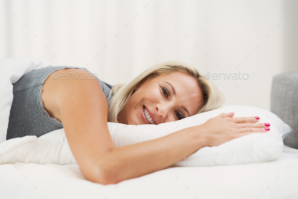 Adult beautiful woman waking up fully rested. Stock Photo by macniak