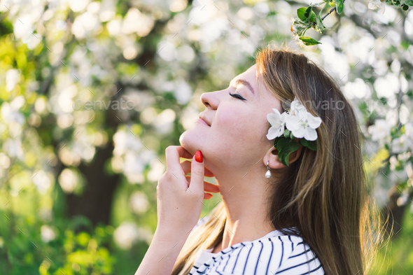 Beautiful young woman with spring flowers enjoying nature and laughing ...