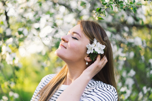Beautiful young woman with spring flowers enjoying nature and laughing ...