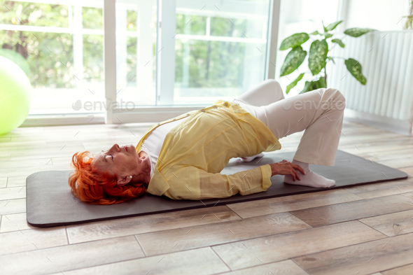 Senior woman doing shoulder supported bridge exercise Stock Photo by ...