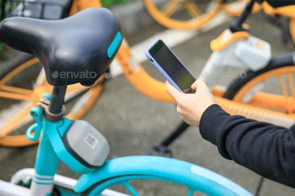 Hand using smartphone scanning the QR code of shared bike in city Stock ...