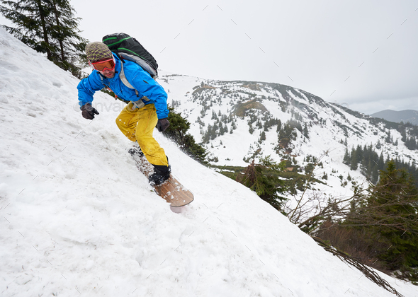 Backcountry extremal male performing professional snowboarding ...