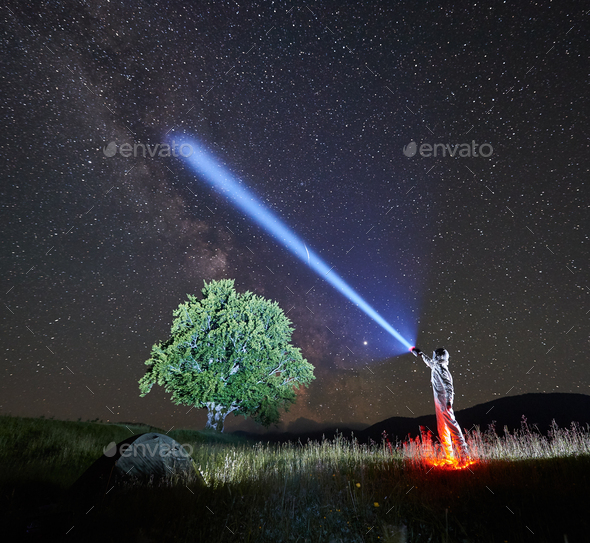 Astronaut shining flashlight into beautiful night sky. Stock Photo by ...