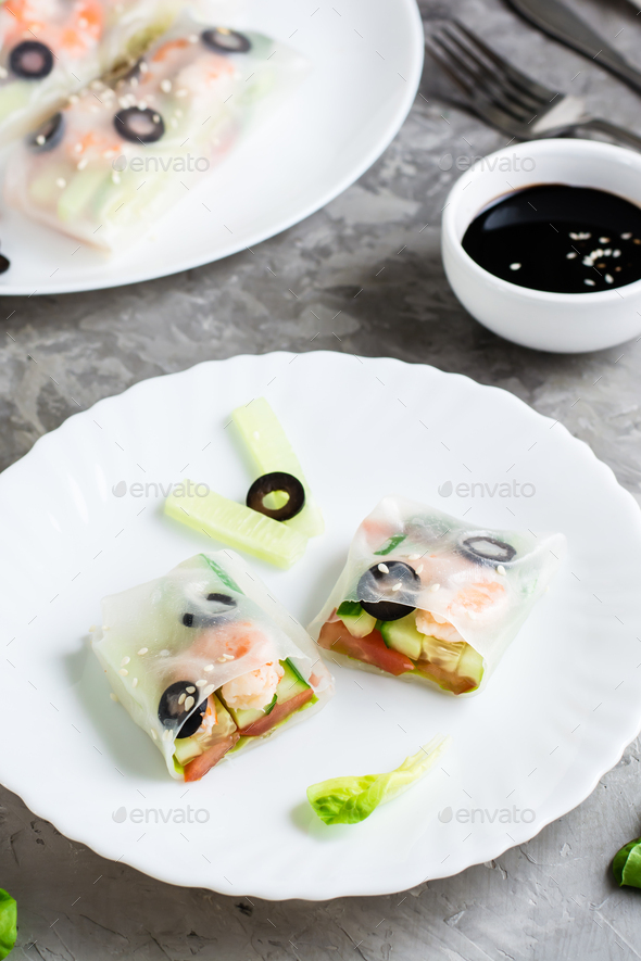 Spring roll cut in half in rice paper with seafood and vegetables on a ...