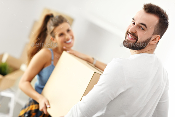 Happy adult couple moving out or in to new home Stock Photo by macniak