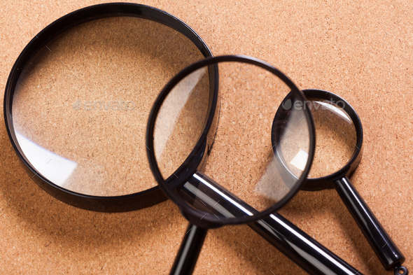 blank brown board and a magnifying glass Stock Photo by FabrikaPhoto