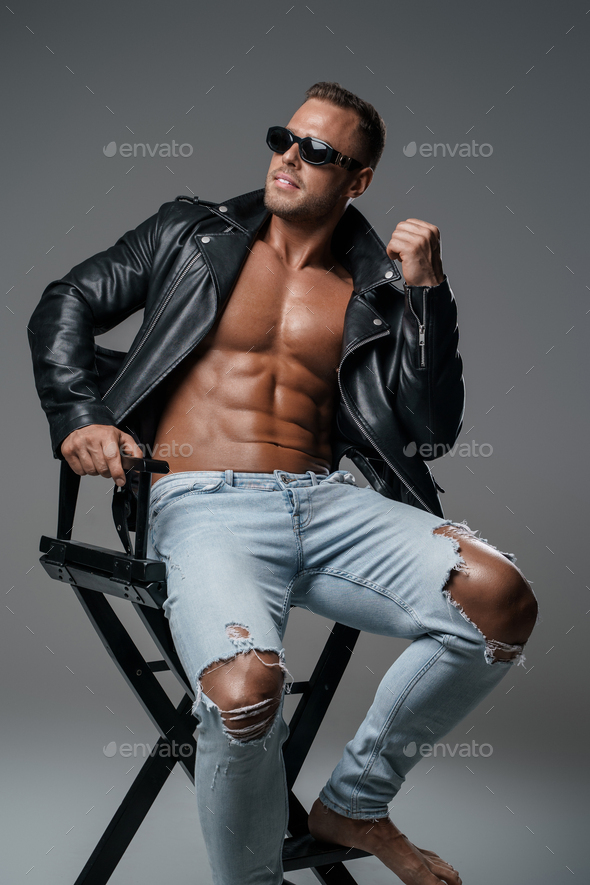 Stylish muscular guy dressed in jeans and leather jacket Stock Photo by ...