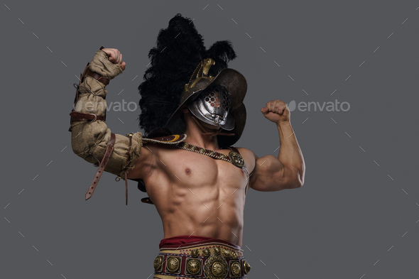 Determined gladiator with muscular body isolated on gray background ...