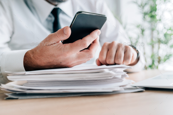 Businessman searching information online while using smartphone over ...