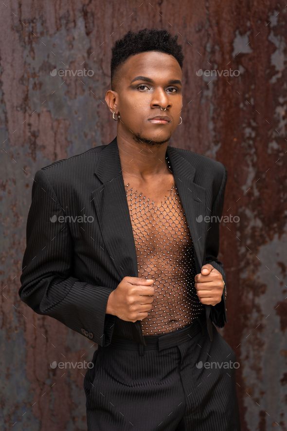 Black ethnic man in a fashion pose on a metallic background with rust ...