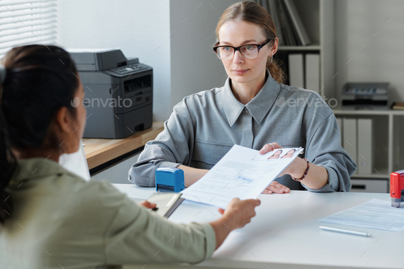 Returning Documents To Applicant At Office Stock Photo by AnnaStills