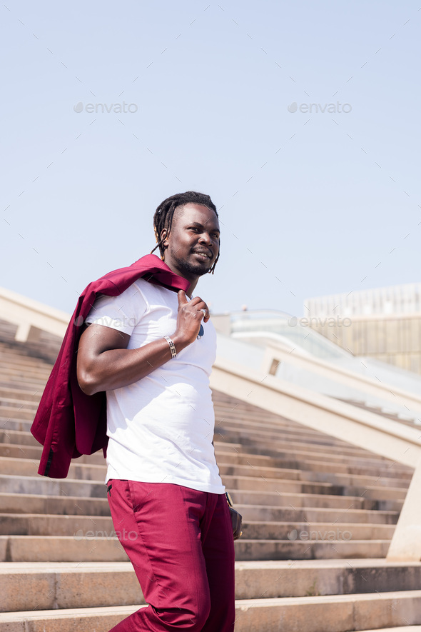stylish black man walking down a city staircase Stock Photo by Raul_Mellado