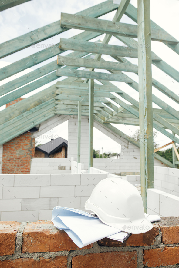 Architecture. House building.Hard hat with house blueprints on brick ...