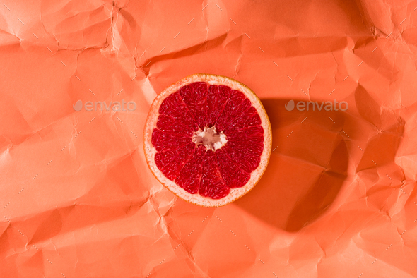 grapefruit half on crumpled paper textured coral surface, color of 2019 ...