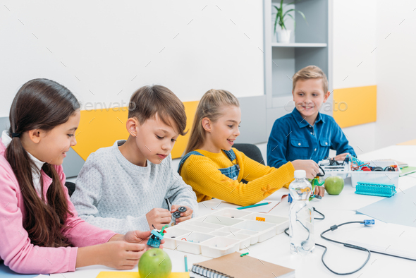 schoolchildren putting a robot together during STEM robotics lesson ...