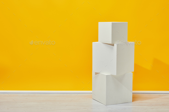 simple white plaster cubes arranged vertically near yellow wall Stock ...