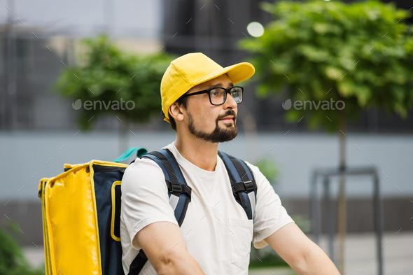 Takeaway, portrait of delivery boy on scooter with yellow isothermal ...