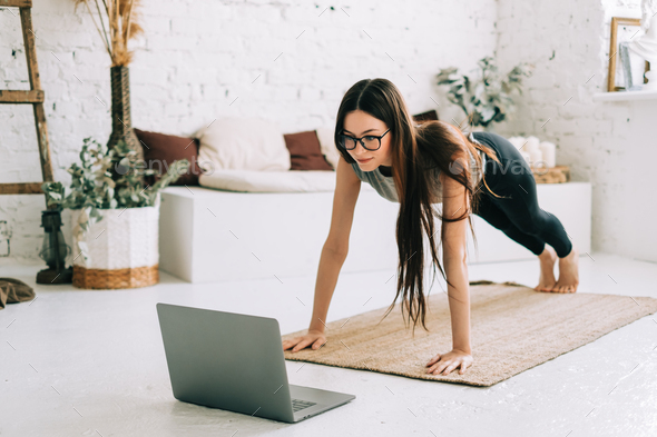 Beautiful brunette fitness woman make stretching exercises in front ...