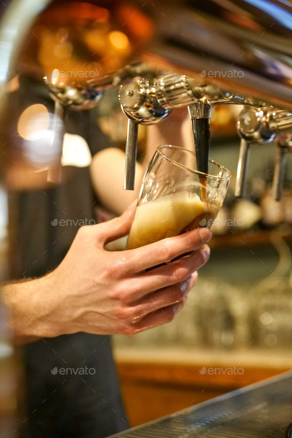 bartender tapping beer in a pub Stock Photo by CCpreset | PhotoDune
