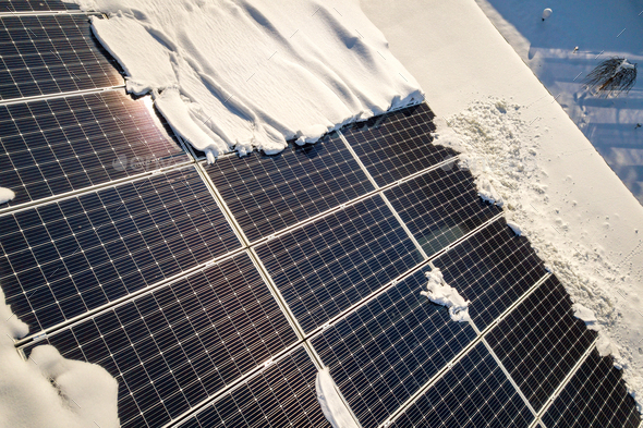 Close up surface of a house roof covered with solar panels in winter ...