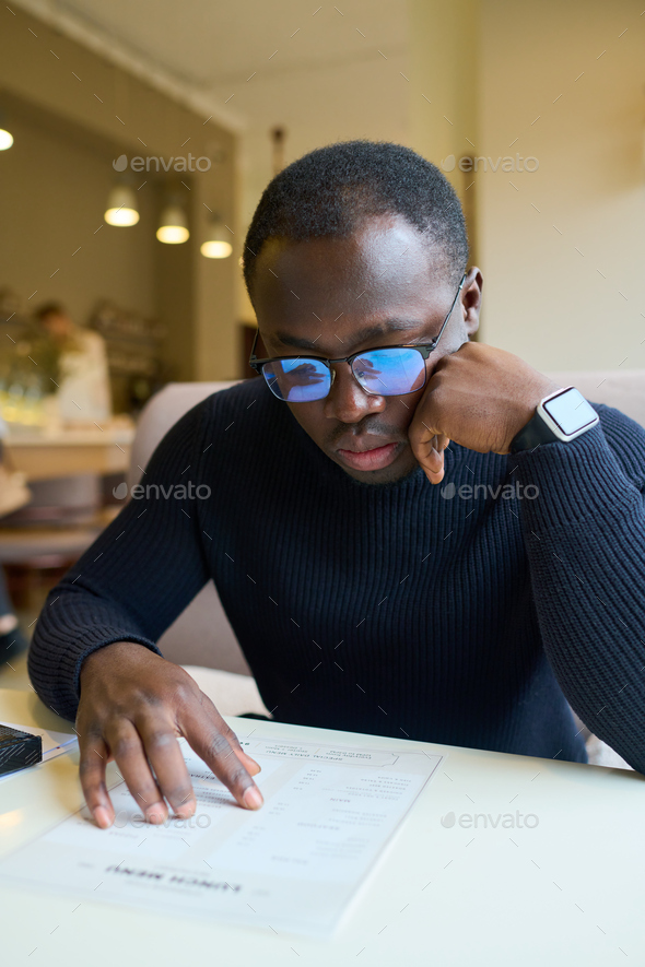 Man examining menu in coffee shop Stock Photo by Pressmaster | PhotoDune