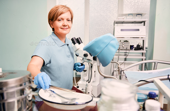 Female gynecologist using colposcope and gynecological instruments ...