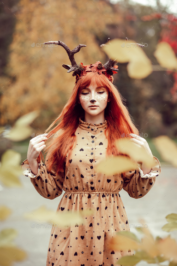 fairy woman with deer horns in autumn forest. Face painting Stock Photo ...