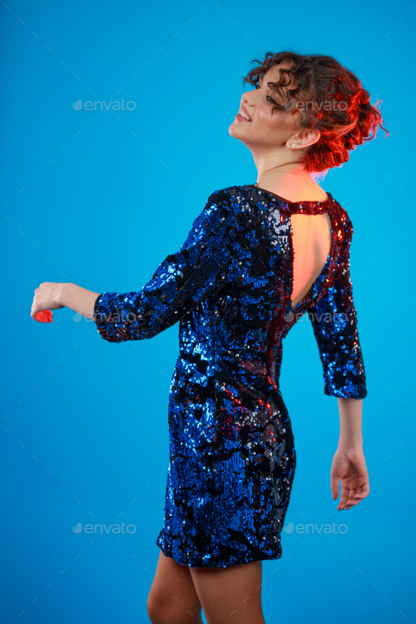 Confident young lady walking on blue background Stock Photo by 13people