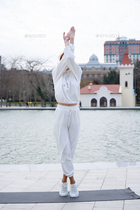 Vertical photo of young girl doing mediation in front of lake Stock ...