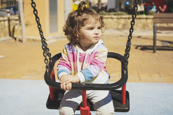 Distracted baby during the playtime sitting in a swing Stock Photo by ...
