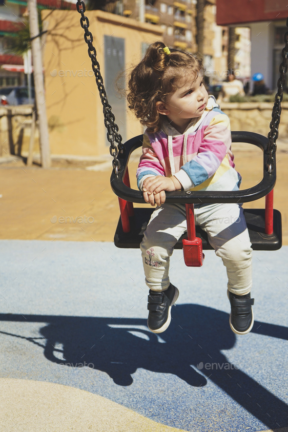 Distracted baby during the playtime sitting in a swing Stock Photo by ...