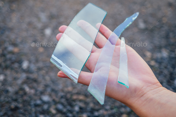 pieces of broken glass on a woman's hand Stock Photo by yurakrasil