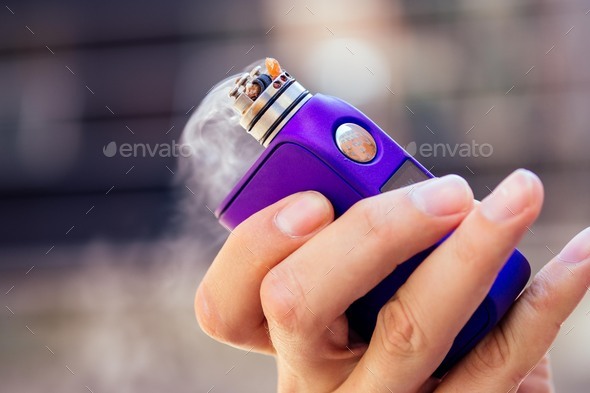 purple vape in a man's hand on a modern background Stock Photo by ...