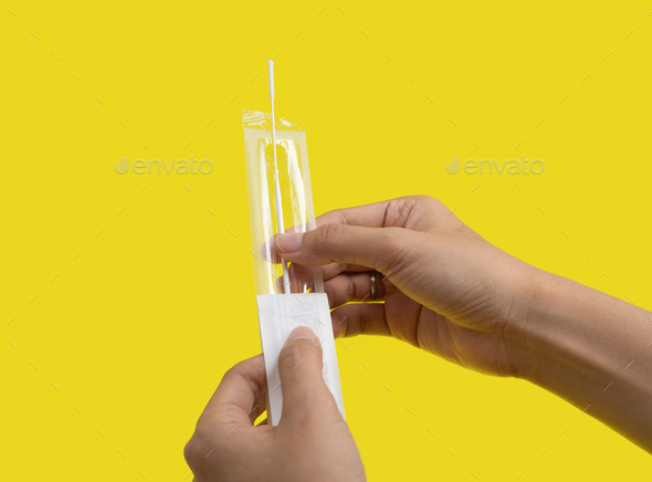 Nasopharyngeal swab on yellow. COVID-19 Ag rapid self test kits ...