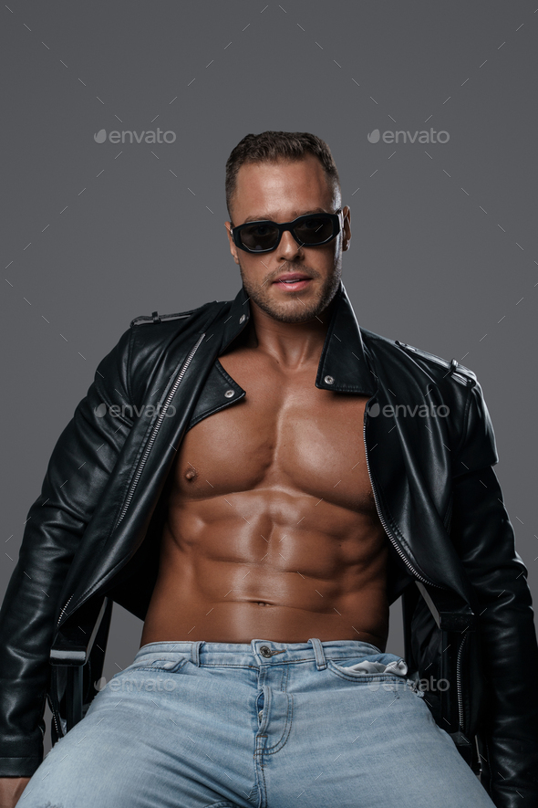 Strong and stylish man sitting on chair against grey background Stock ...