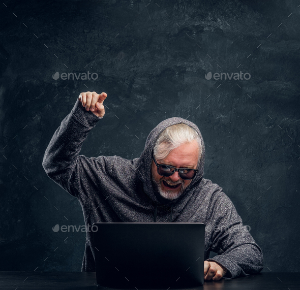 Angry old man hacker with laptop against dark background Stock Photo by ...