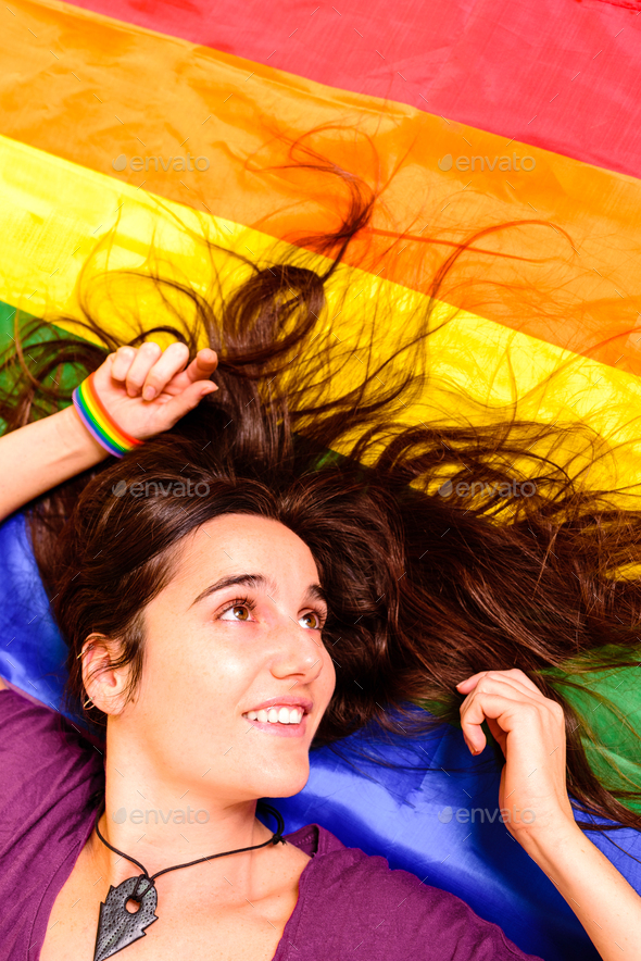 Young student girl lying on a gay flag viewed from above. Stock Photo ...