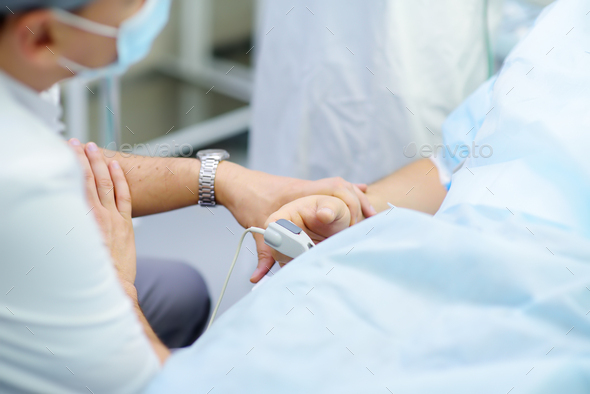 Doctor checking oxygenation with fingertip pulse oximeter during ...