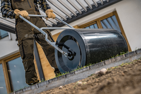 Professional Landscaper Pushing Large Grass Roller To Flatten Newly ...