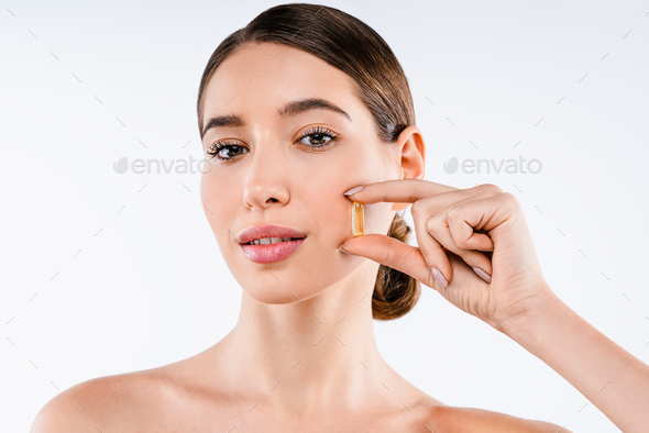 Close up beauty portrait of woman showing beauty pill capsule standing ...
